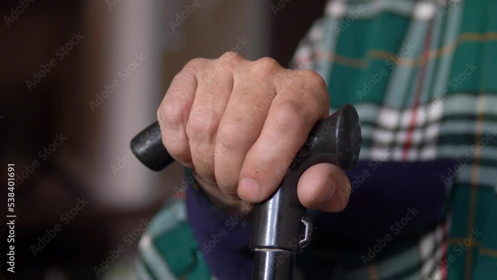 close-up of the hand of an elderly person holding a walking stick ...