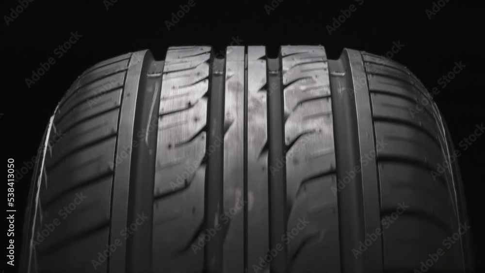 Rotating Tire on a Black Background. The surface of a car tire covered ...