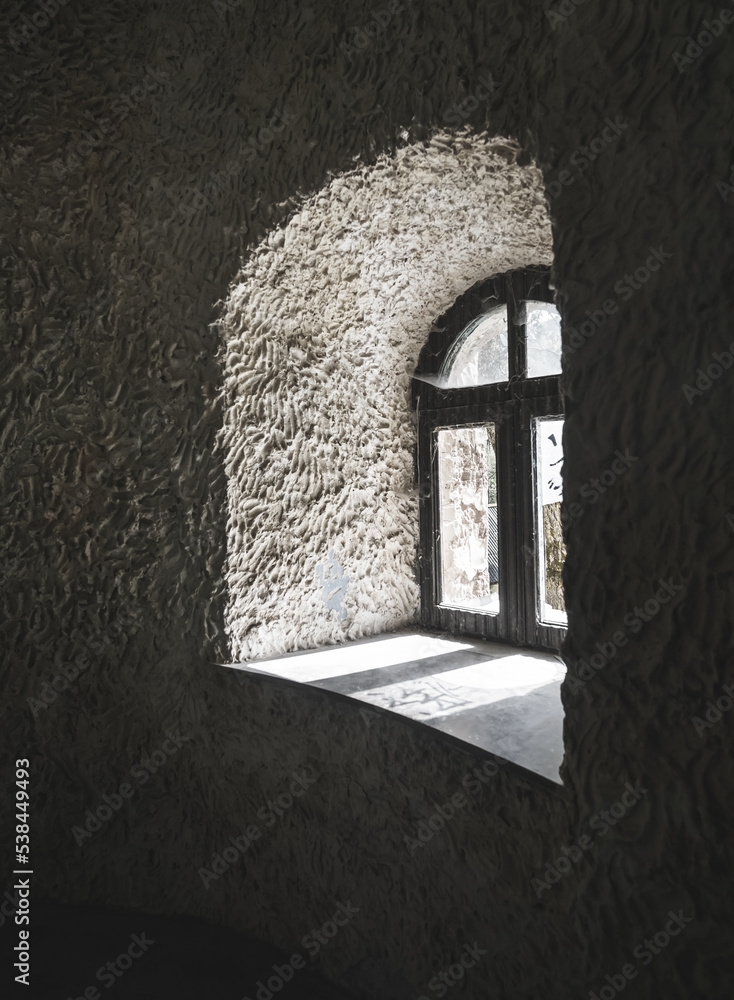 In an old castle, a window shines into a dark room inside; lining with ...