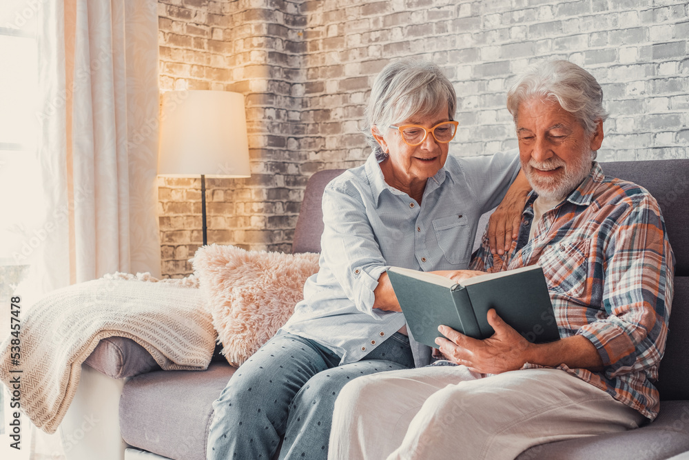 Portrait of couple of two cute grandparents reading a book together ...