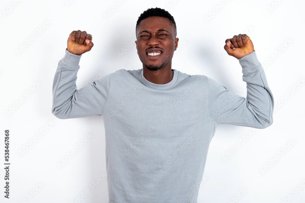 Strong powerful young handsome man wearing grey sweater over white ...
