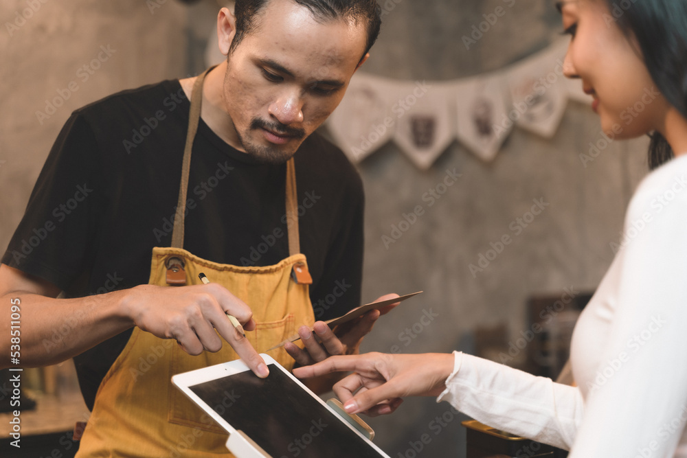 woman customer in restaurant choosing food on menu in tablet and waiter ...