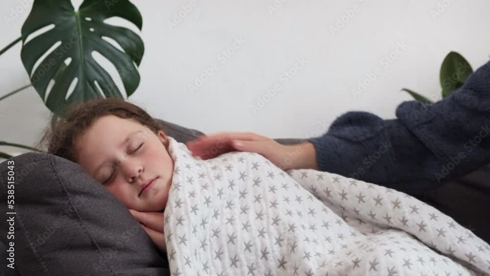 Caring mom covering sleepy little girl with blanket or plaid. Loving ...