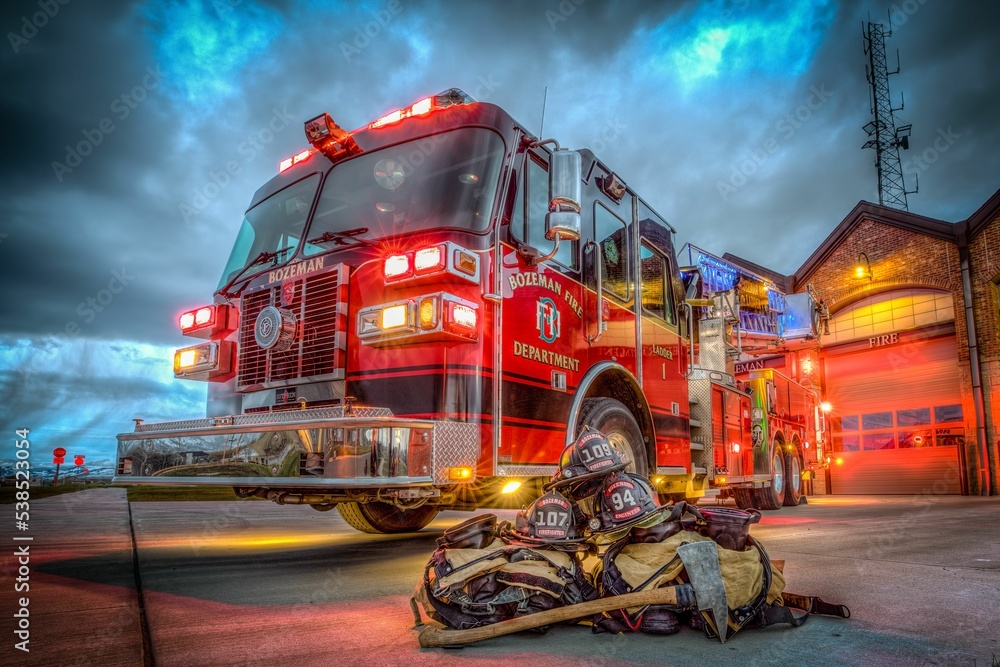 Low-angle of a 3D rendered ladder truck and fire station at dusk with ...