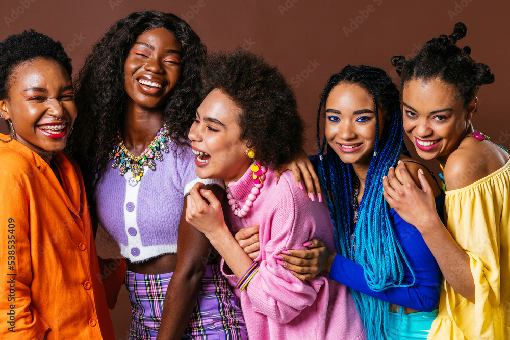 Group of Beautiful black women posing in studio on colored background ...