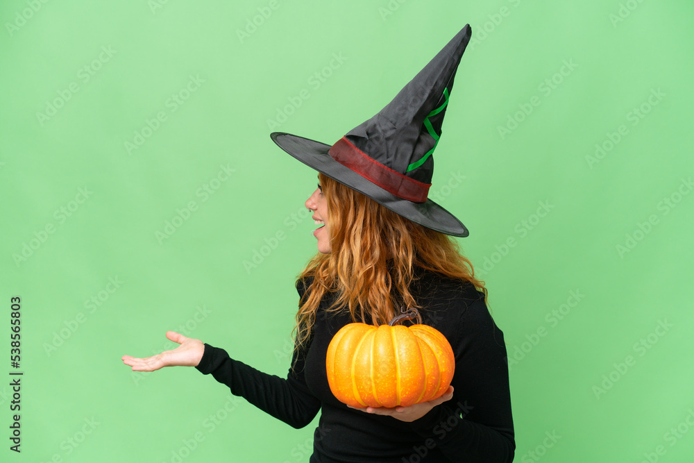 Young caucasian woman costume as witch holding a pumpkin isolated on ...