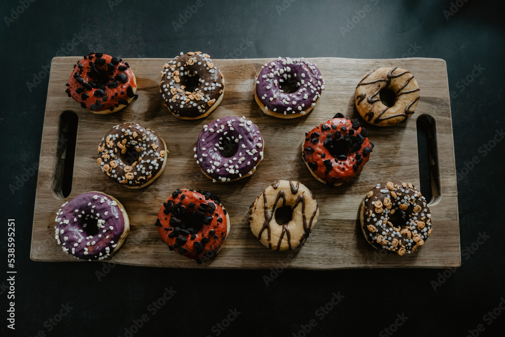 conjunto de donuts de diferentes colores con chocolate y azúcar encima ...