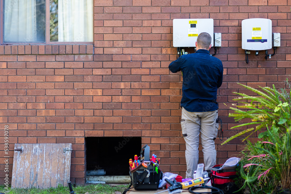 Electrical tradie working as an electrician doing a solar power ...