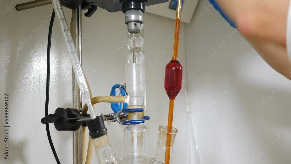 Laboratory in chemical plant. Scientist sampling chemical extract from ...