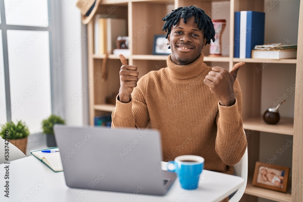 Young african man with dreadlocks working using computer laptop success ...