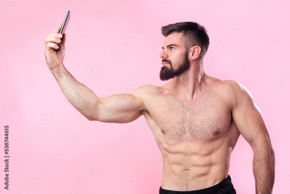 Foto de Strong and muscled bodybuilder taking a selfie with his ...