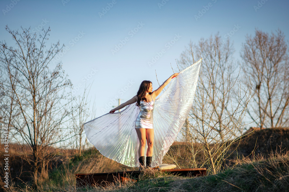 Young beautiful woman with dancing wings, dancing in nature, enjoying ...