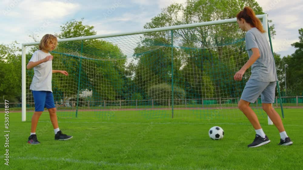 Mother, son playing soccer for fun outdoors in park. Happy family ...