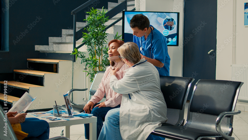 Medical staff removing cervical neck collar off of elderly patient with ...