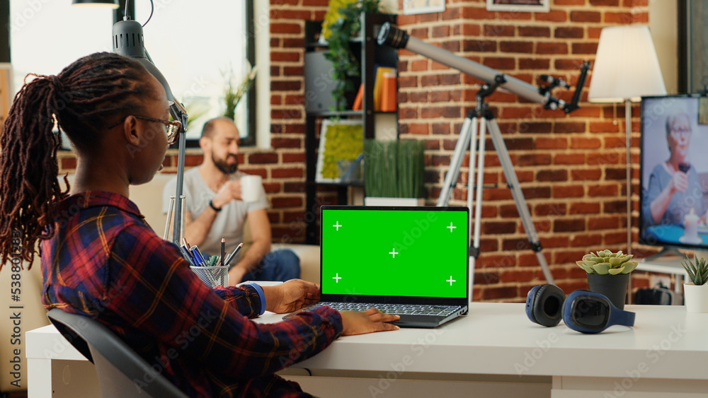 African american woman working with greenscreen display on laptop ...