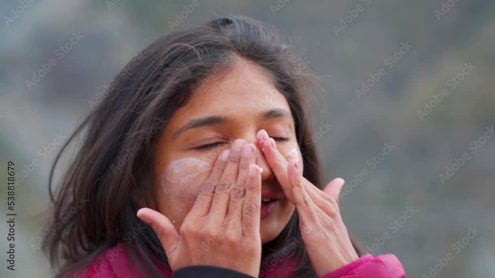 Portrait of happy smiling Indian teenager girl applying moisturizer ...