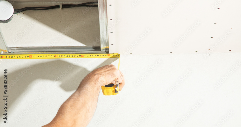 Measurement of ceiling connected to gypsum frame. Stock Photo | Adobe Stock
