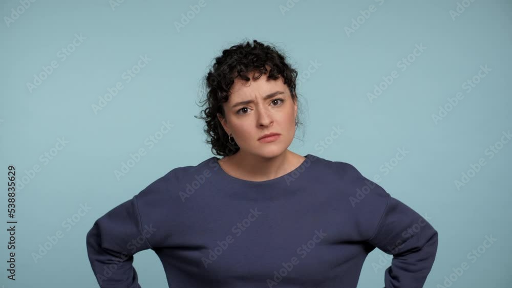 Close up beautiful angry curly woman turns her head and angrily looks ...