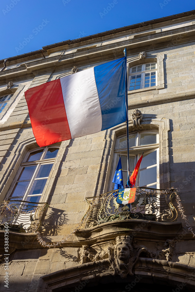 Large French flag waving in the wind in front of an official building ...