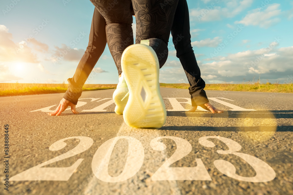 Foto de Female legs of runner at start on road close-up. Running into ...