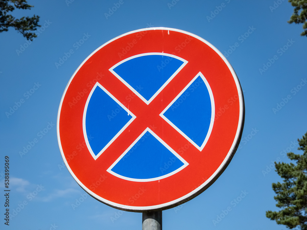 Metal signwith a red circle and red cross over a blue background ...