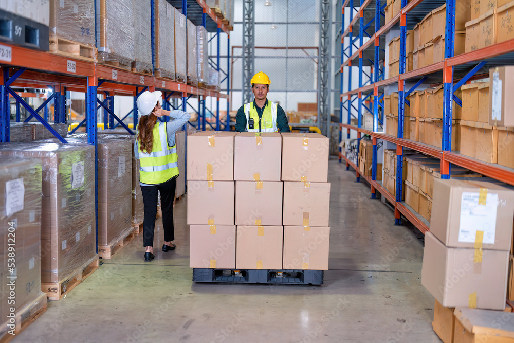 Warehouse worker pull manual pallet hand truck stack with boxes walk ...