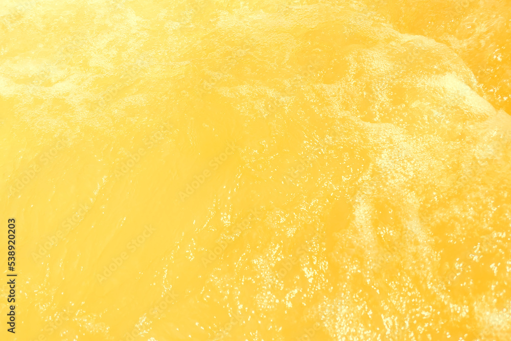 Defocus blurred transparent yellow colored clear calm water surface ...
