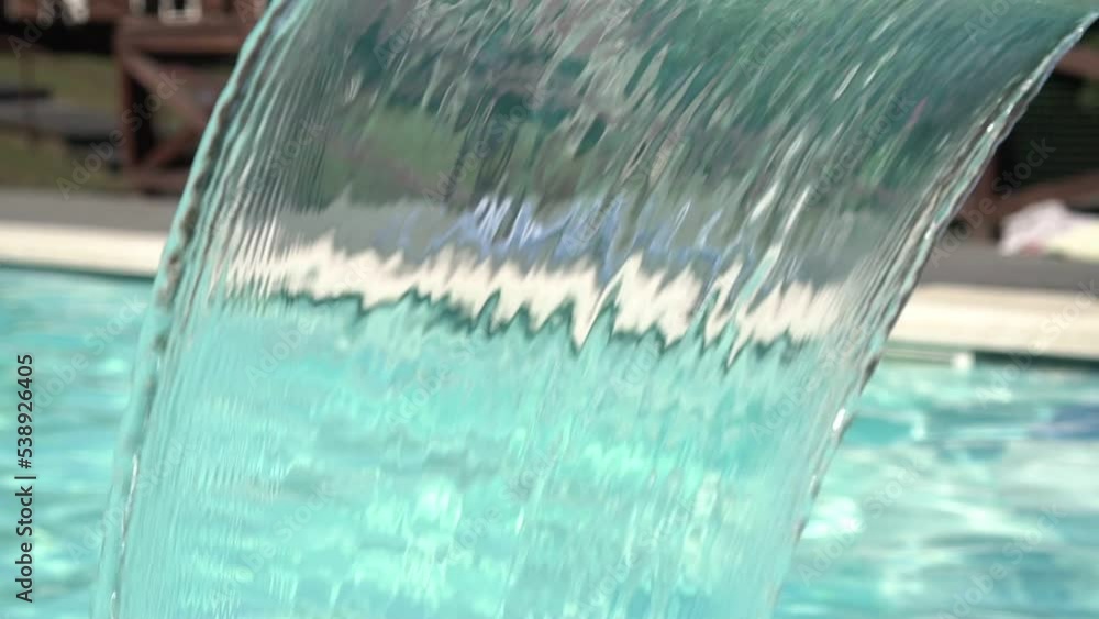 Waterfall, jet of water in the pool, slow motion. Vacation and relaxing ...