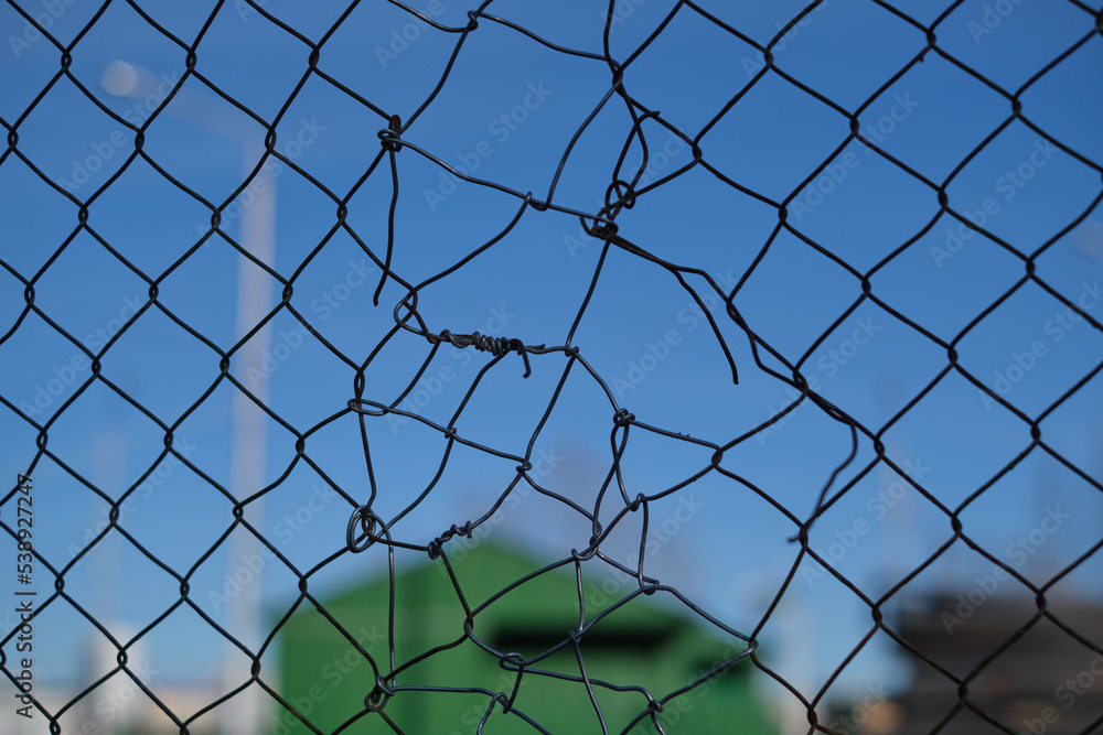 Hole in the fence. Mesh wire boundary. Steel mesh barrier fence. Chain ...