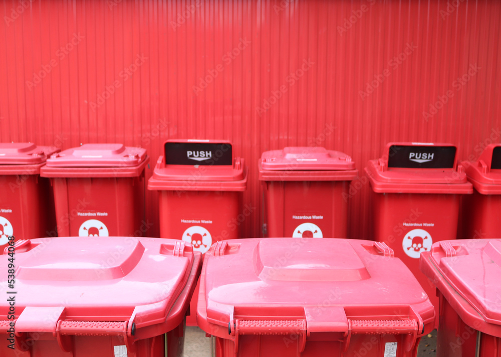 Stack of biological biohazard infected red bins. Sign showing the ...
