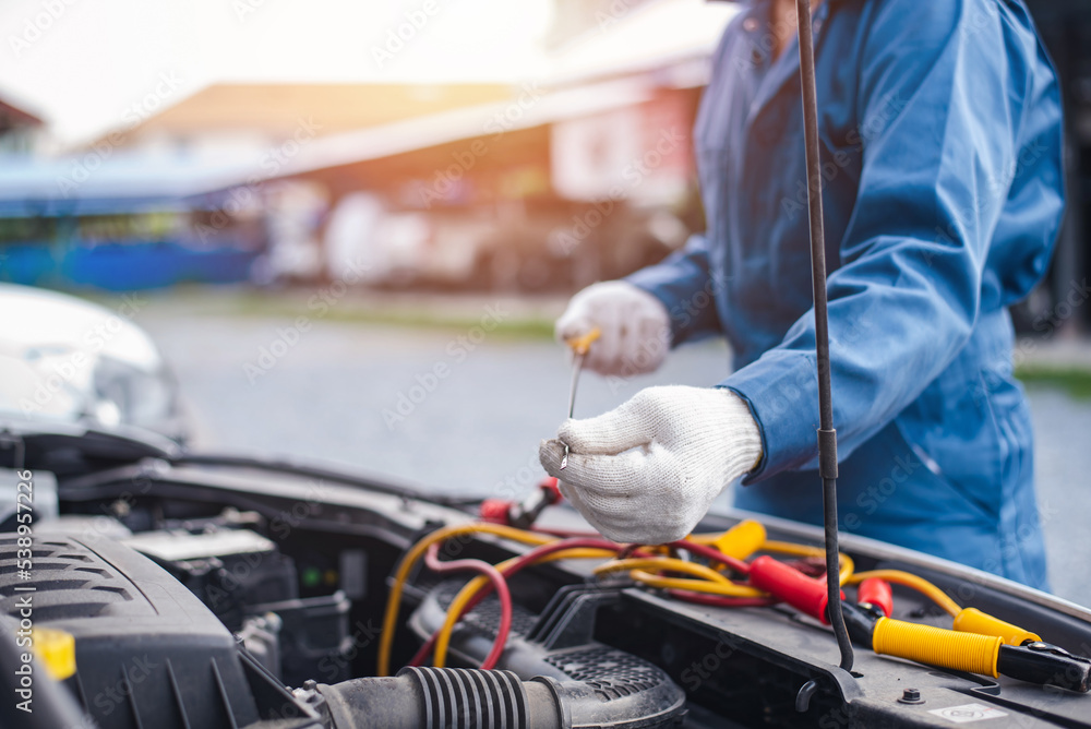 Mechanic checking the oil level in a car engine, Asian auto technician ...