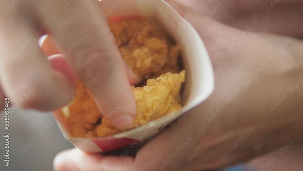 The girl is holding a cardboard tray with fast food. Woman's hand close ...
