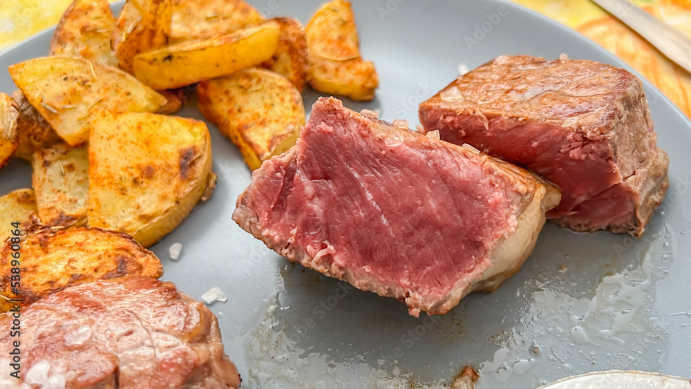 Filetto di manzo cotto al sangue e servito con patate al forno come ...