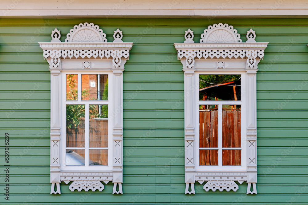 Old wooden green windows with carved architraves. Log facade of a ...