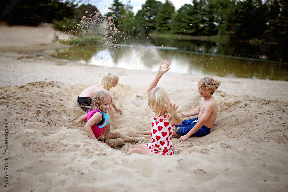 Happy Kids Playing Outside in the Sand at the Beach by the Swimming ...