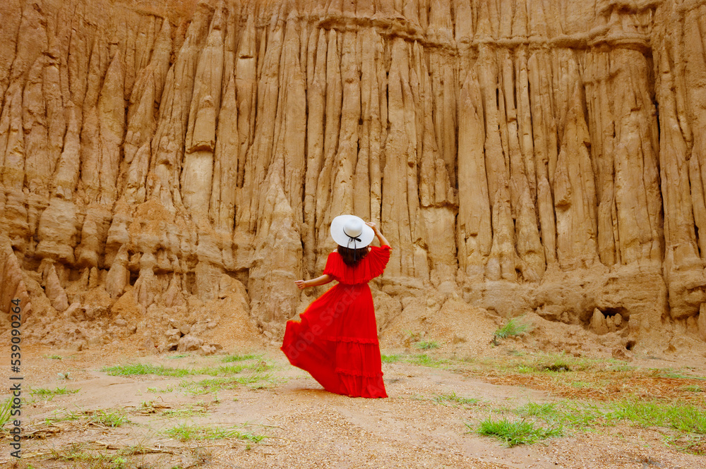 Women and landscape of soil textures eroded sandstone pillars, columns ...