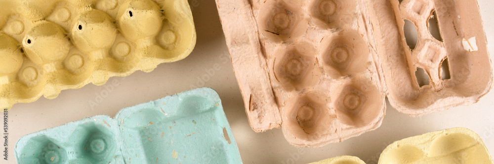 Eco pulp egg cartons made with pulp and straw over light brown ...