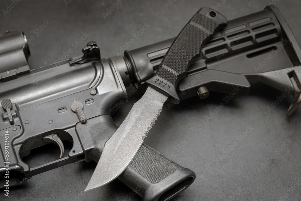 Fixed blade combat knife and assault rifle, close-up photo. Stock Photo ...