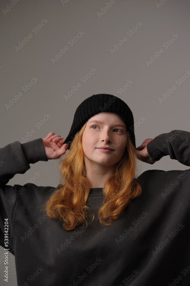 young girl model in black cap and coat isolated on grey background ...