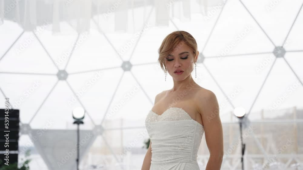 A white long wedding dress on a model during a photo shoot. A beautiful ...