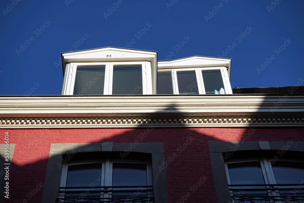 Weiße Mansarden und Dachgauben auf dem Dach eines Altbau vor blauem ...
