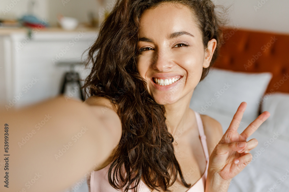 POV of happy Caucasian young brunette woman posing to smartphone camera taking selfie photo and ...
