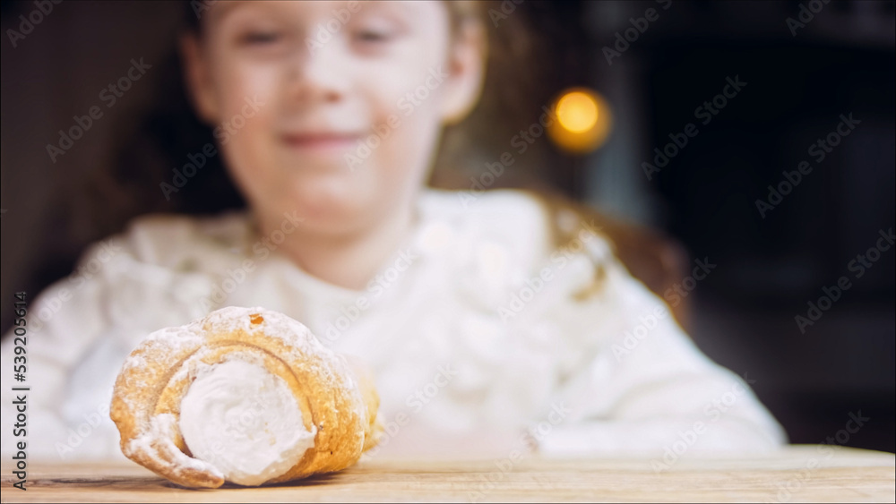 Puff pastry with cream. The cake is round in shape. The girl is eating ...