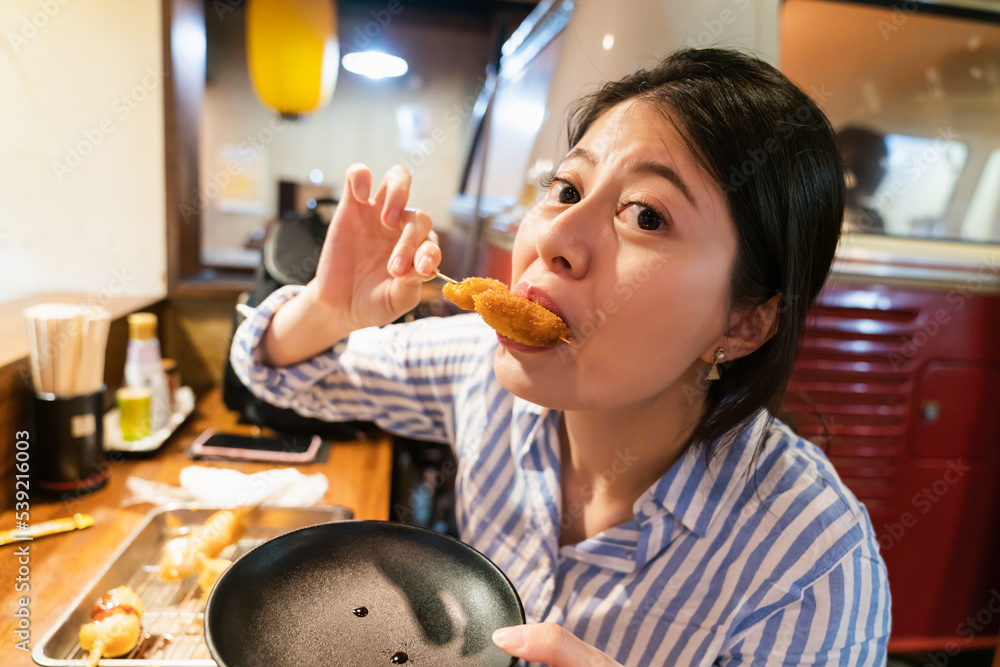 headshot of hungry asian Japanese female diner looking at camera while ...