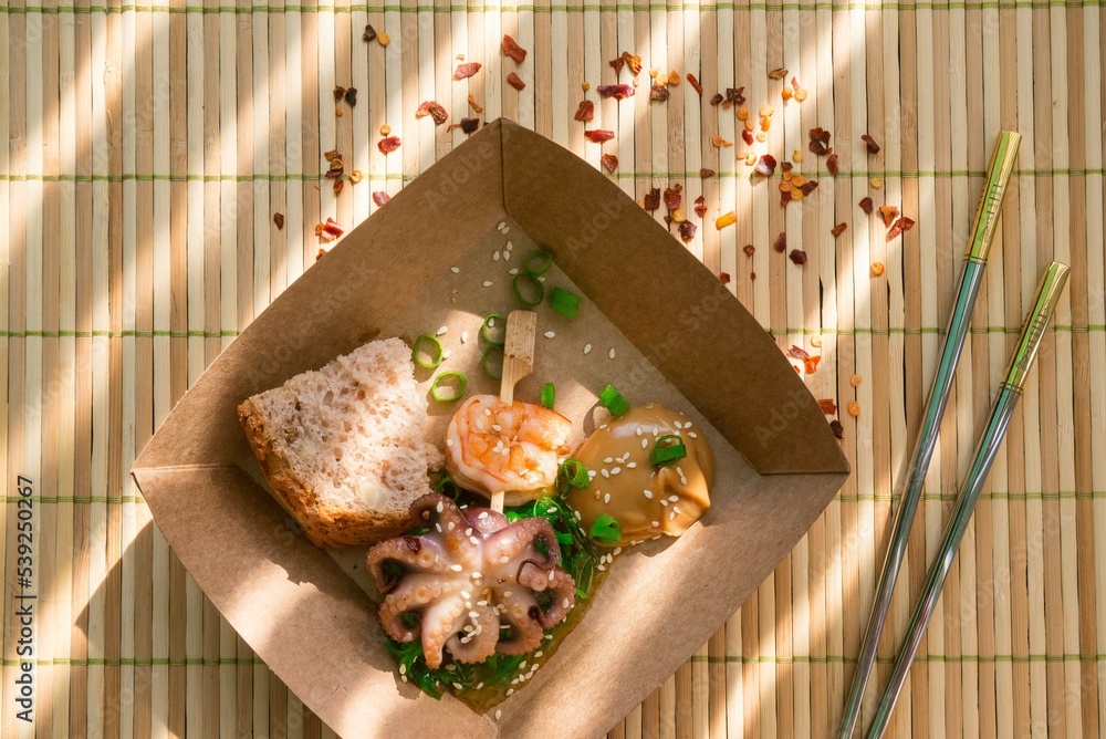 Paper plate with a portion of seafood, shrimp, octopus, Chuka seaweed ...