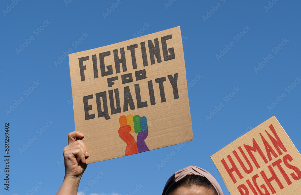 People holding placard signs slogans Fighting for Equality, with ...