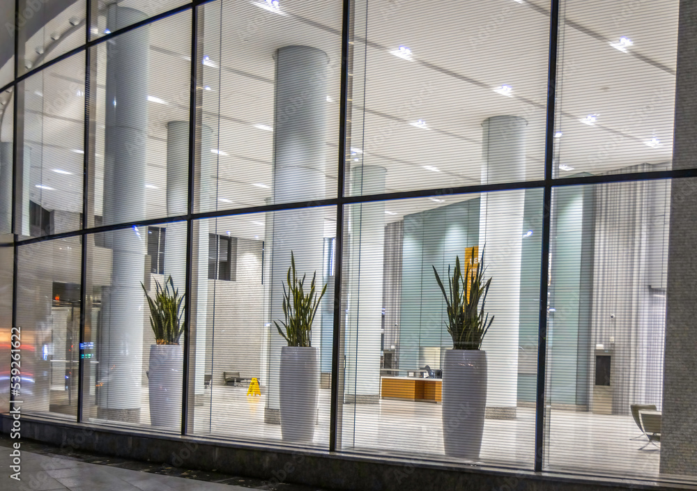 Typical empty commercial building lobby at night, large curved window ...