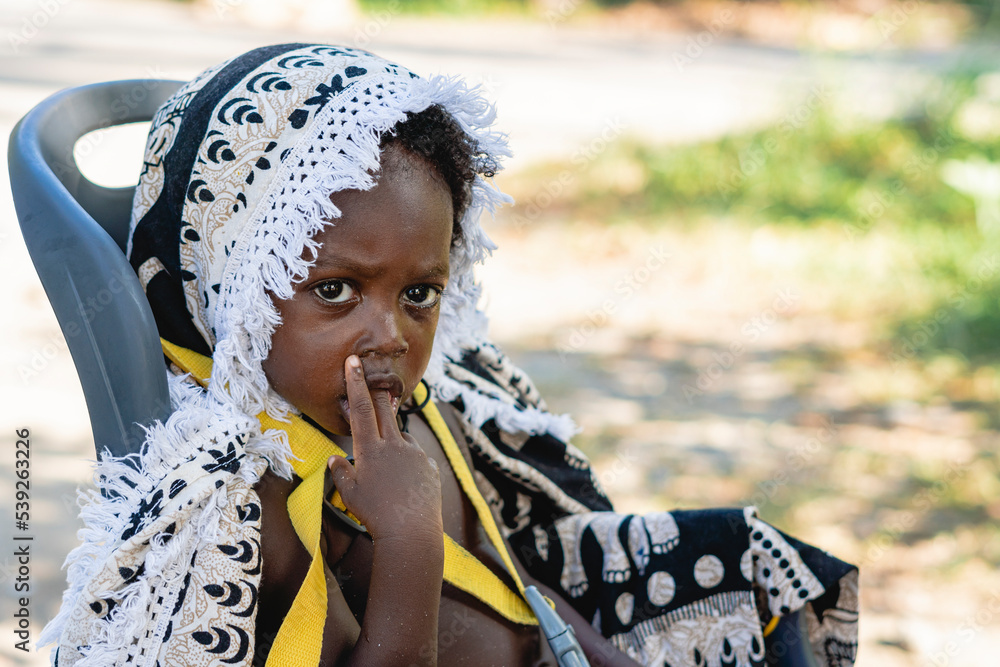 Imagen horizontal de un niño afroamericano mirando seriamente a cámara ...
