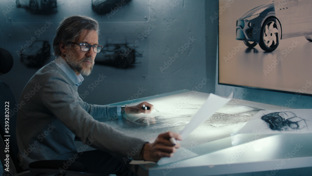 An automotive engineer and designer transfers sketches of prototype car ...