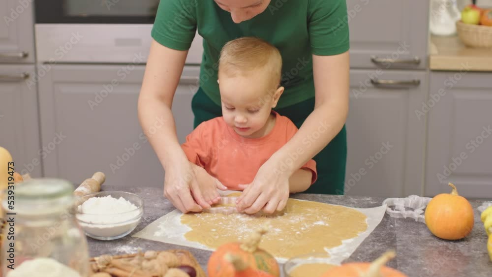 female and little baby child cooking homemade cookies together orange ...